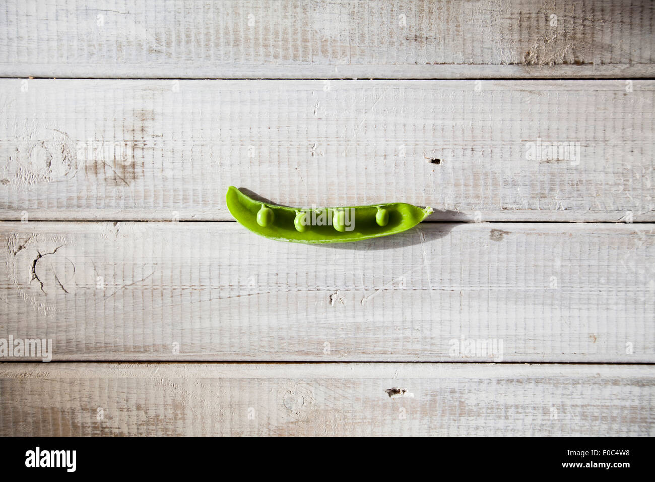 Four peas on a white table Stock Photo - Alamy