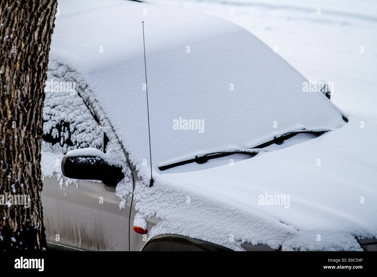 Winter scene, car covered with light dusting of snow, needing to be ...
