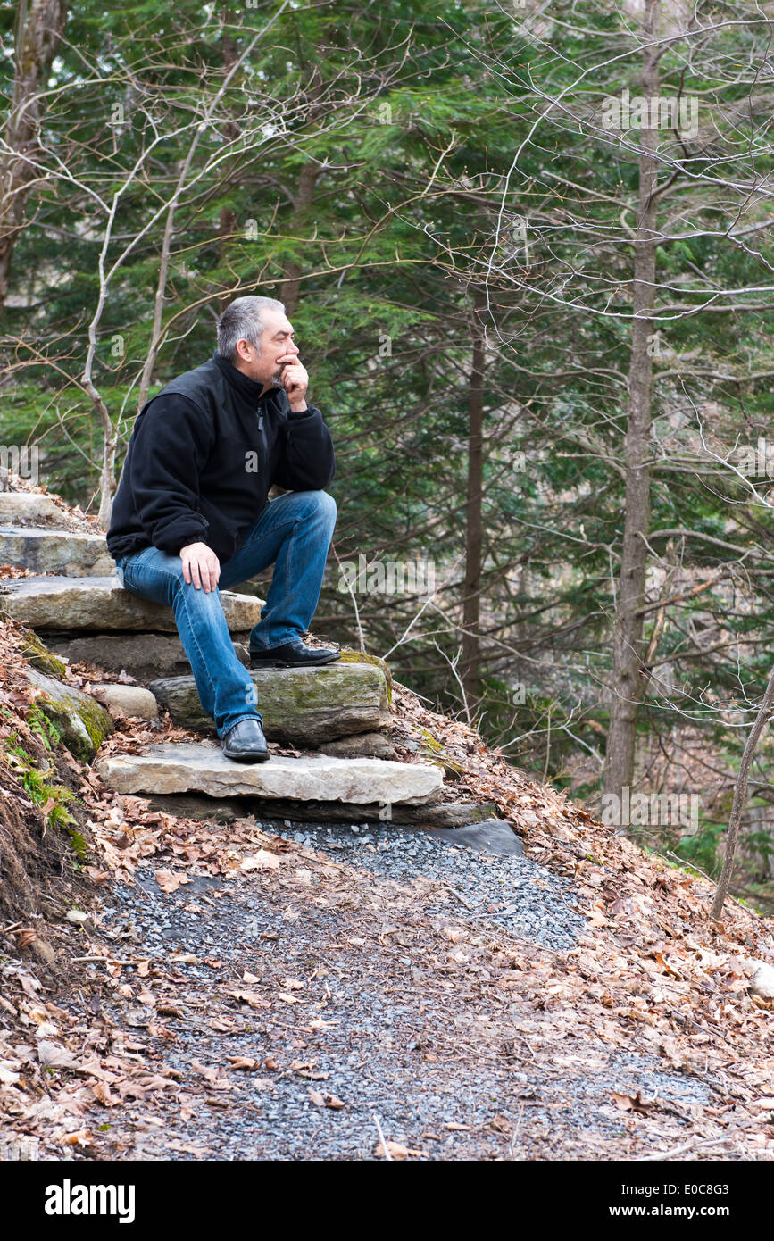 Sad man sitting on rocks hi-res stock photography and images - Alamy