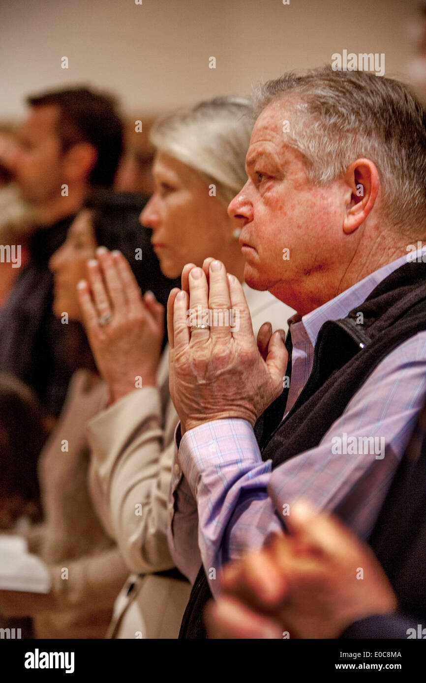 Parishioners hold their hands in prayer during mass at St. Timothy's ...