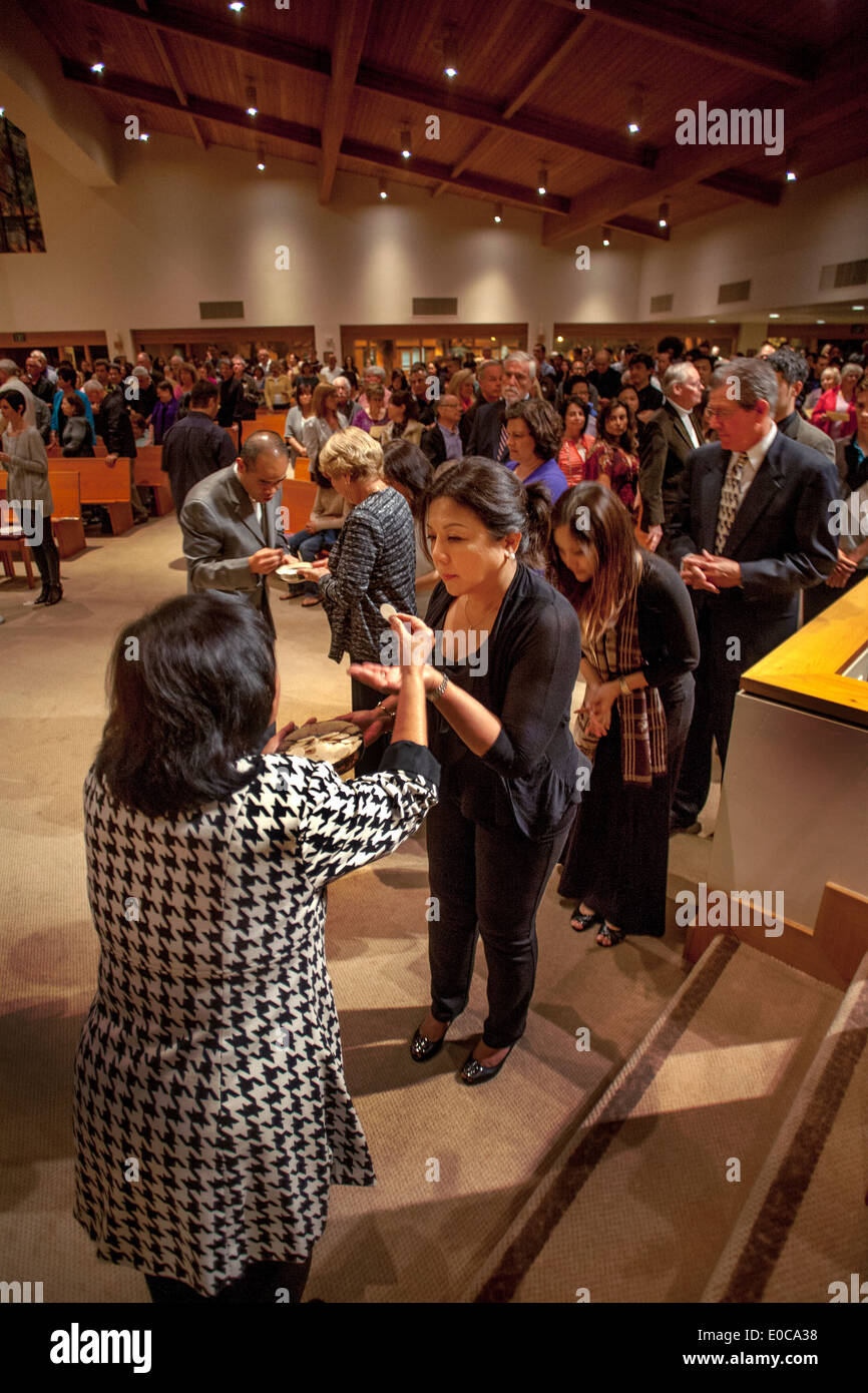 Altar servers offer host wafers to the congregation during communion ...