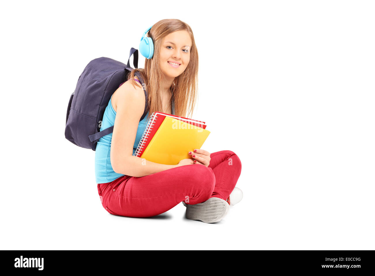Beautiful female student with backpack sitting on the floor Stock Photo ...