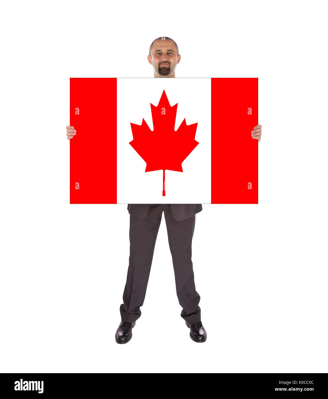 Smiling businessman holding a big card flag of Canada isolated on white ...