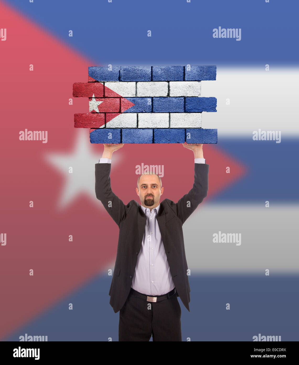 Businessman holding a large piece of a brick wall flag of Cuba isolated ...