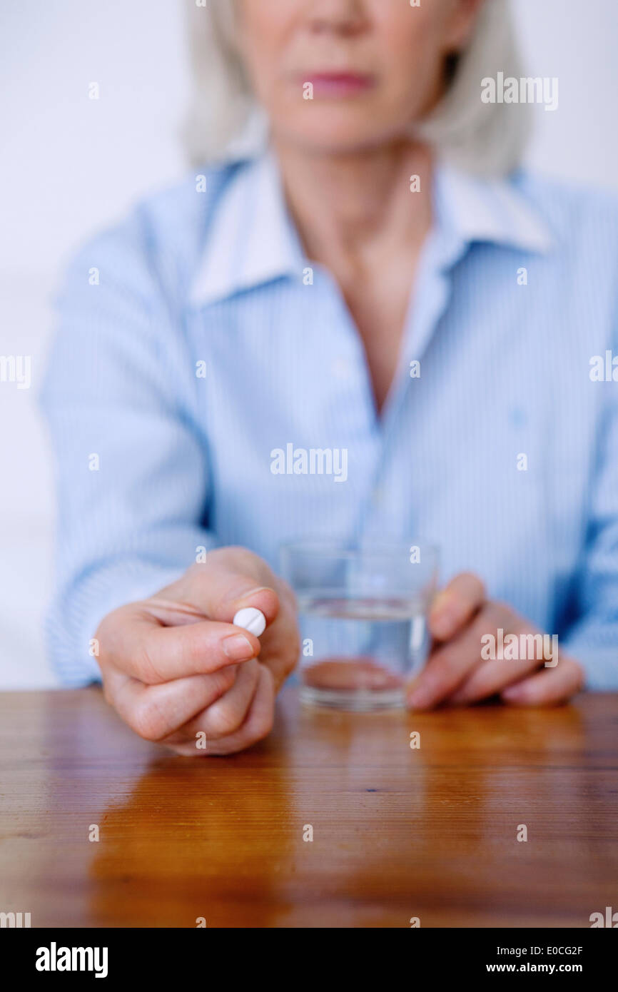 Woman taking medication seated hi-res stock photography and images - Alamy