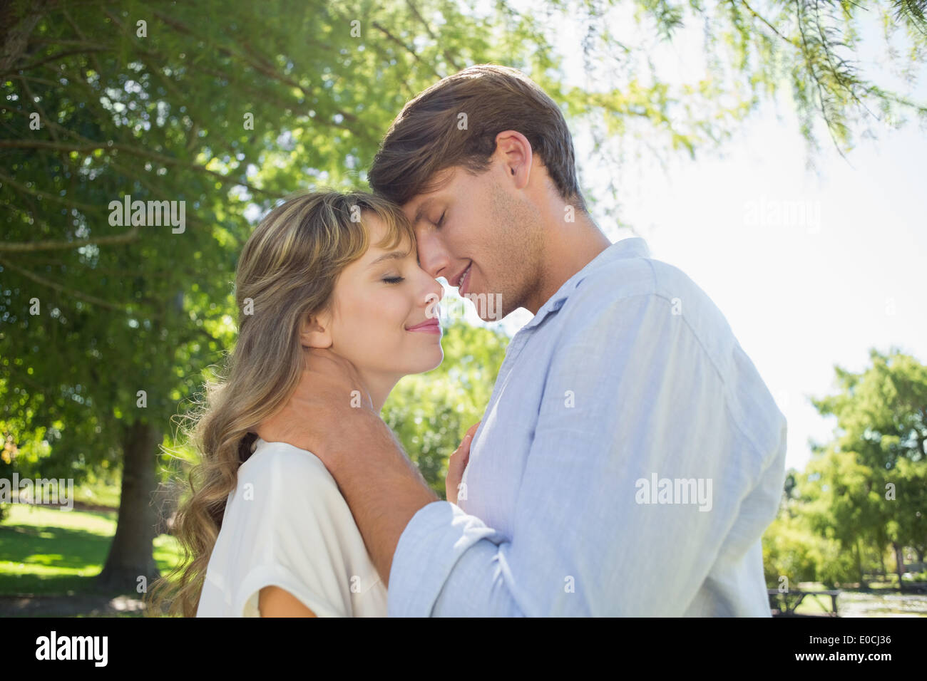 Cute couple hugging and smiling in the park Stock Photo - Alamy