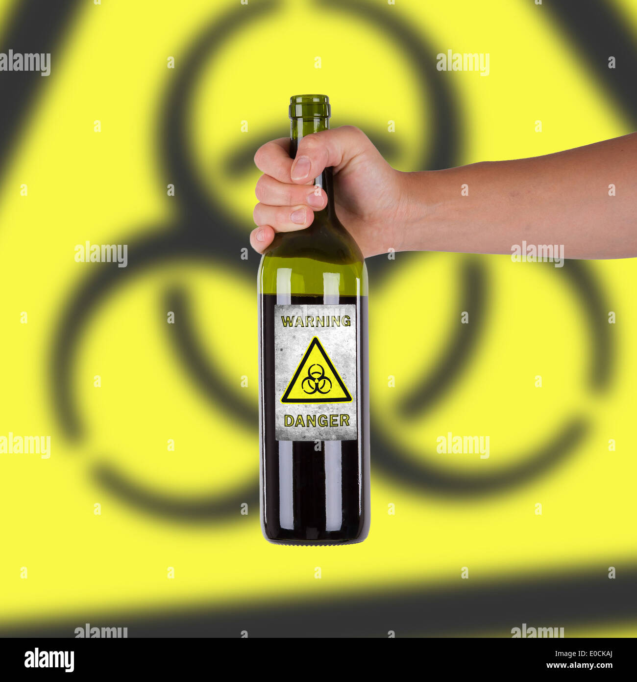 Hand holding a bottle with a warning biohazard Stock Photo - Alamy