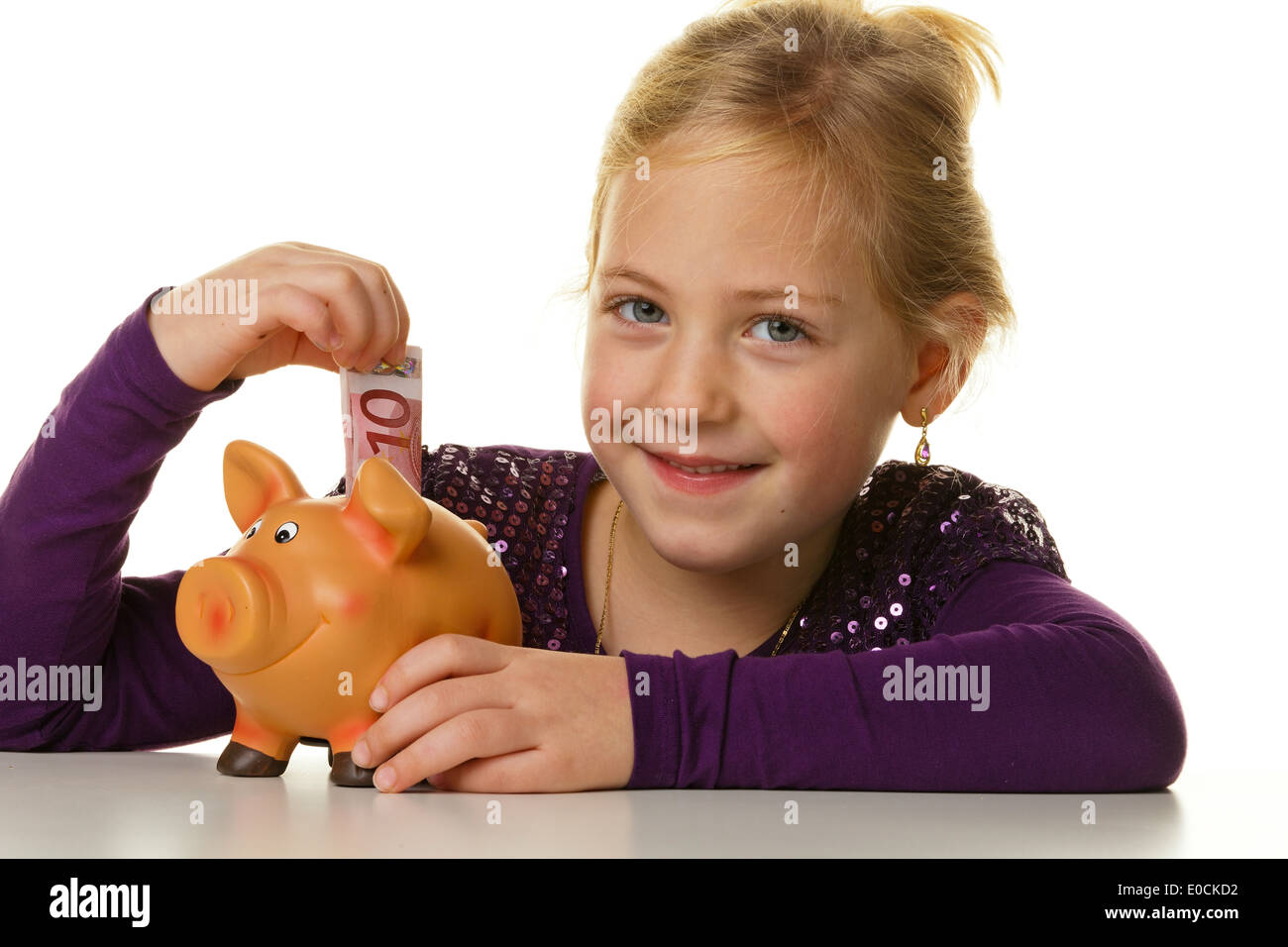 A small child puts a bank note in a piggy bank Stock Photo - Alamy