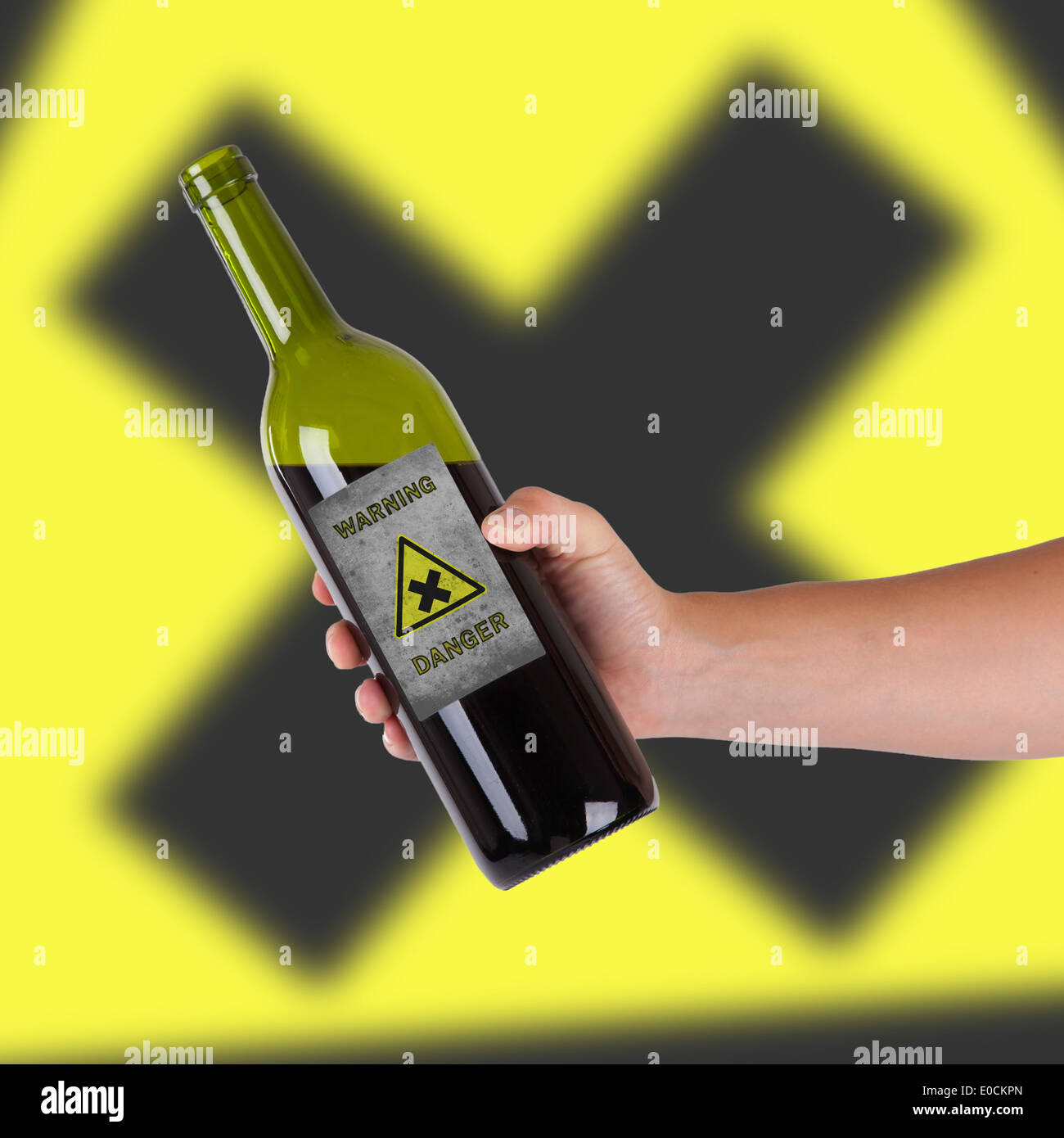 Hand holding a bottle with a warning danger Stock Photo - Alamy
