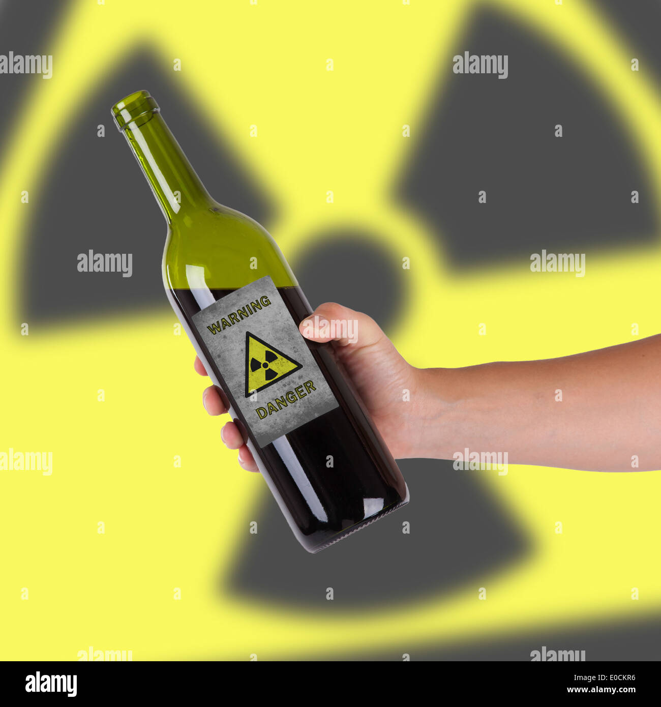 Hand holding a bottle with a warning radioactive Stock Photo - Alamy
