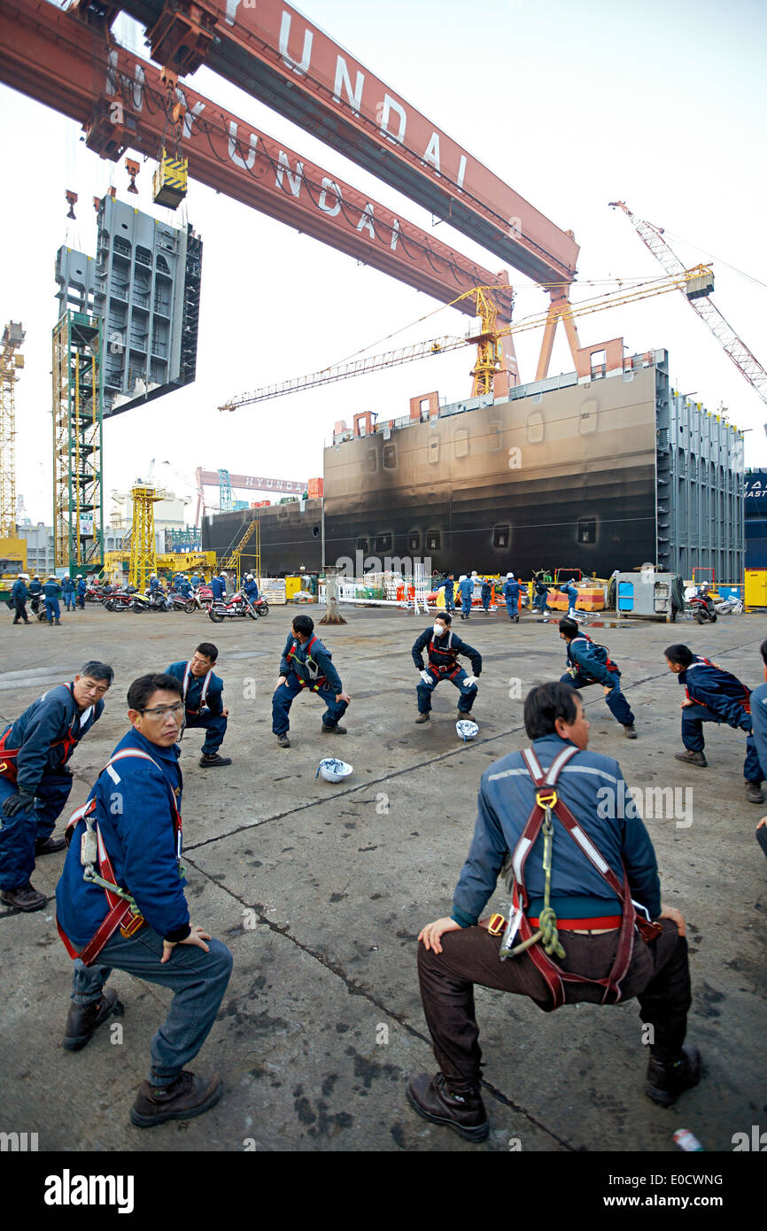 Shipyard workers doing morning exercises before shift, modular ...