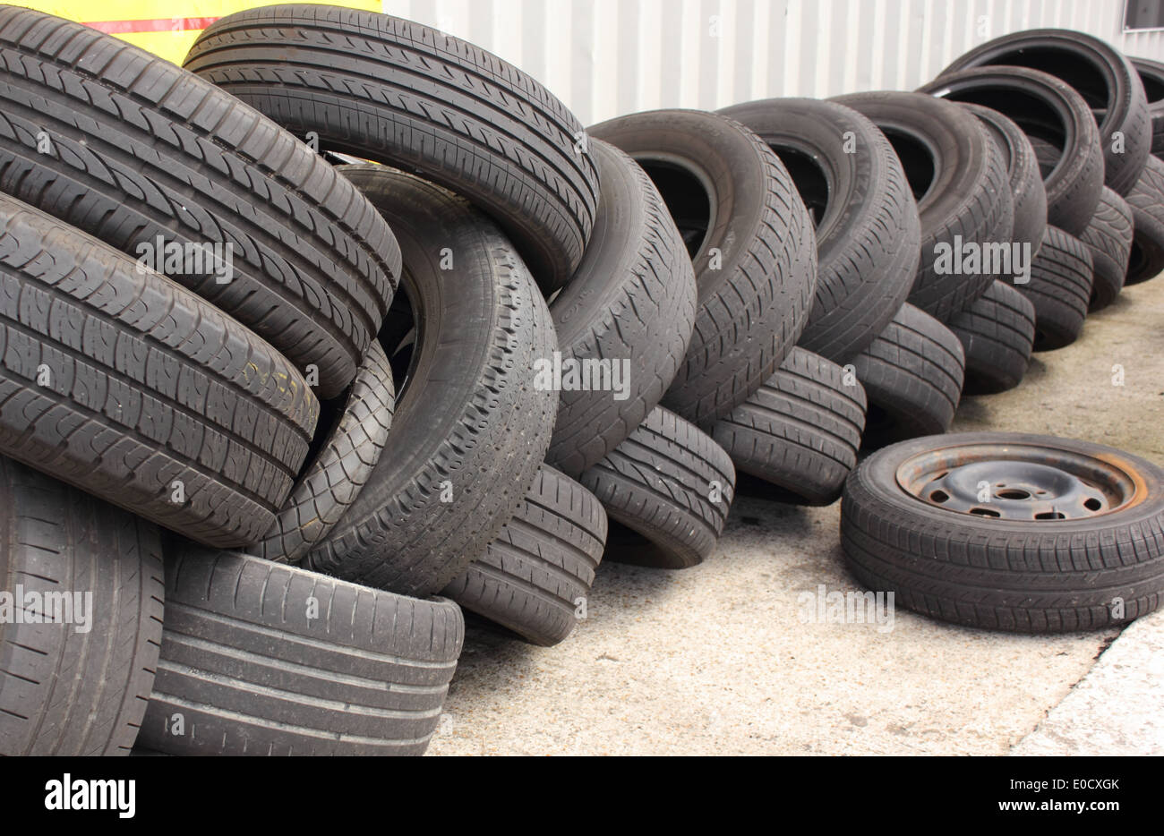 A collection of old worn out tyres at a service centre ready for ...