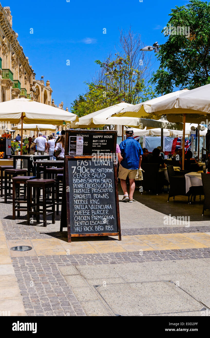 Tourists walk past a menu-board and through a typical restaurant with ...