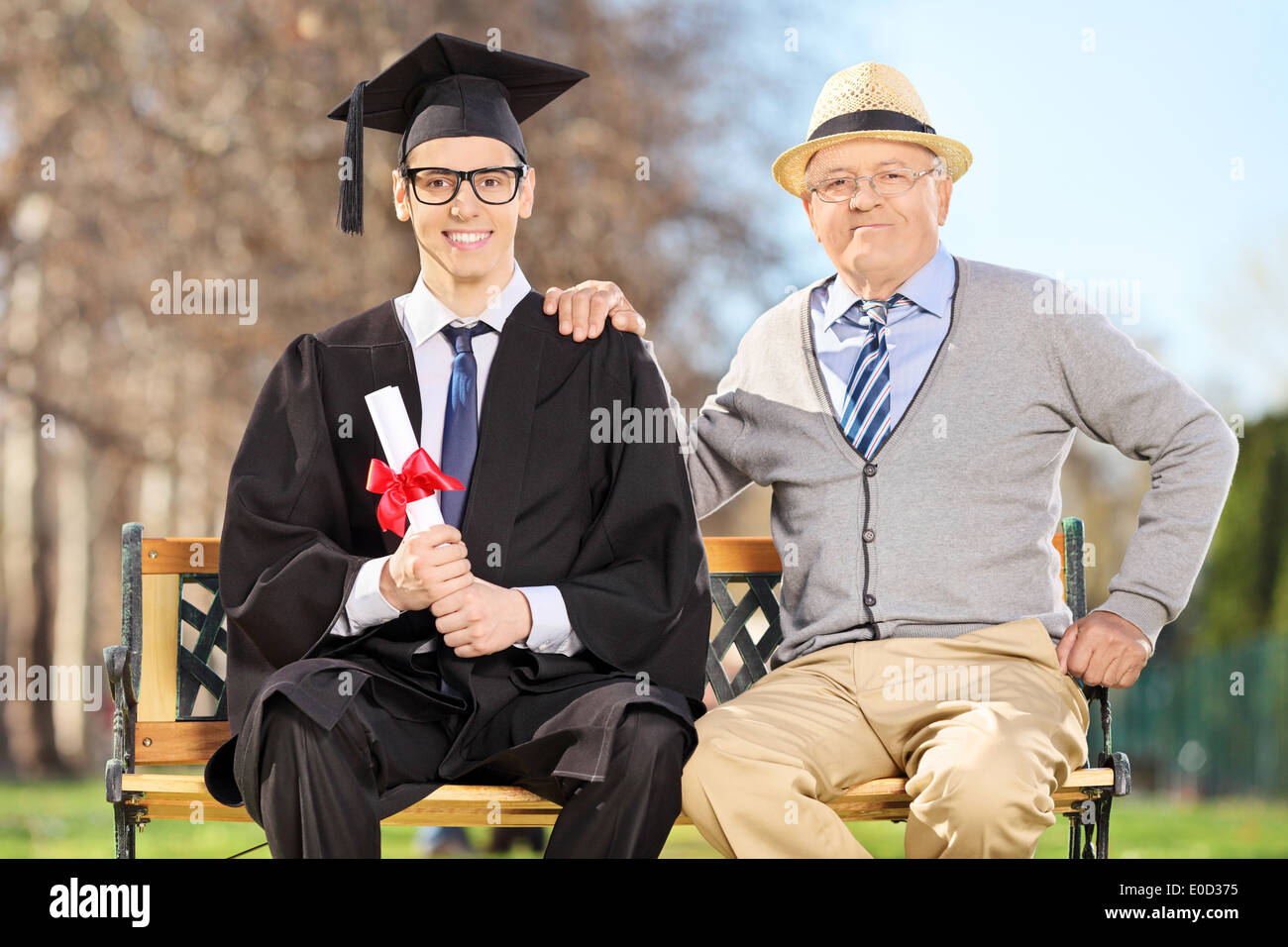 Male graduate posing with his father in park Stock Photo - Alamy