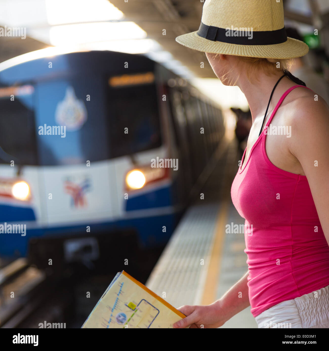 Young woman on platform of railway station Stock Photo - Alamy