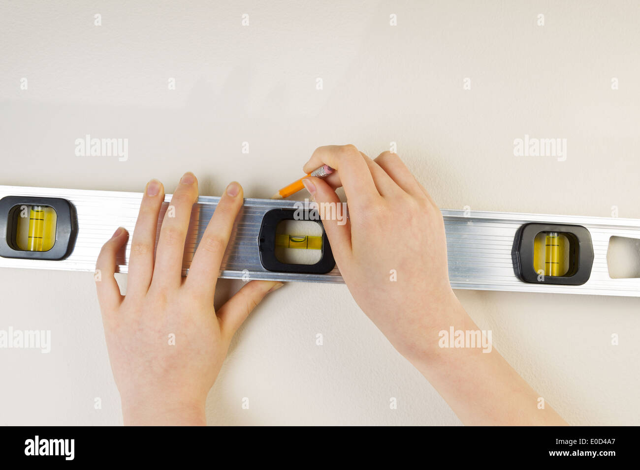Horizontal photo of female hands using level and pencil on interior ...