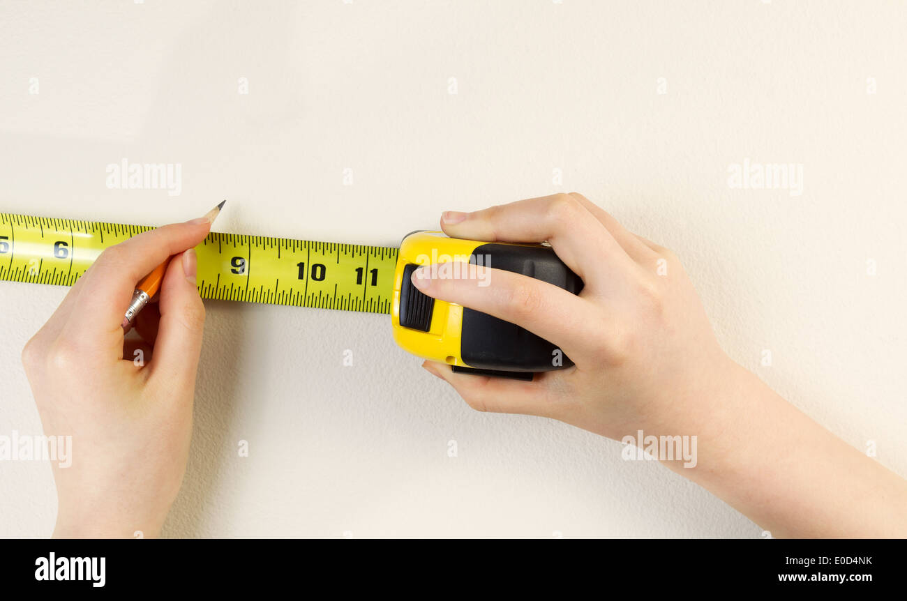 Horizontal photo of female hands using tape measure and pencil on ...