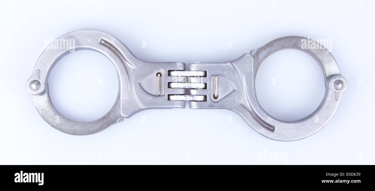 Metal handcuffs isolated on a grey background Stock Photo - Alamy