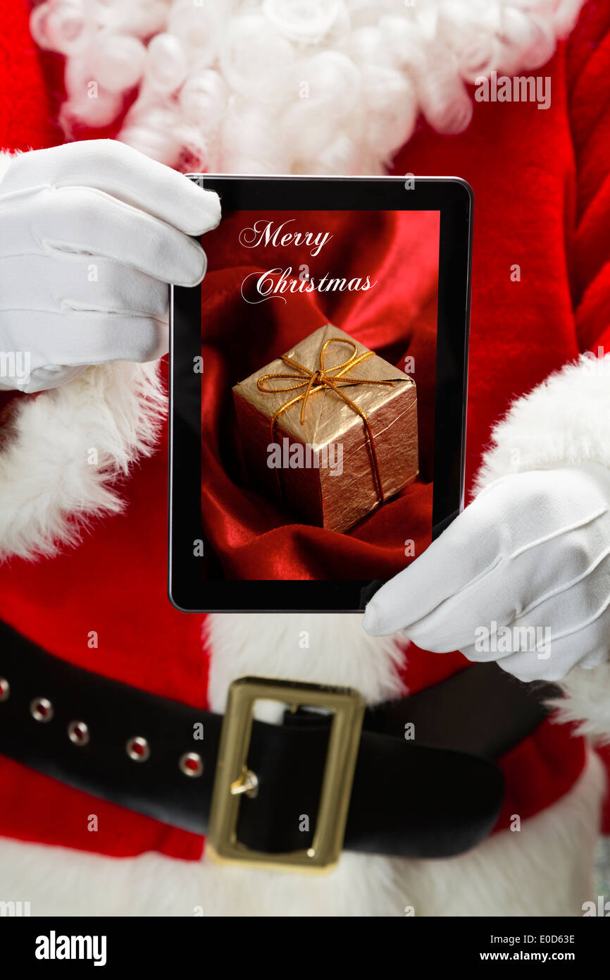 Santa Claus holding tablet with image of gift Stock Photo - Alamy