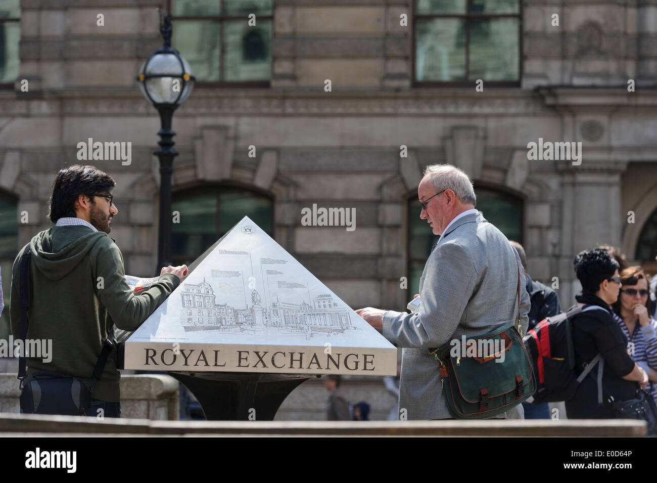 Tourists looking at a detailed map of buildings near the Royal Exchange ...