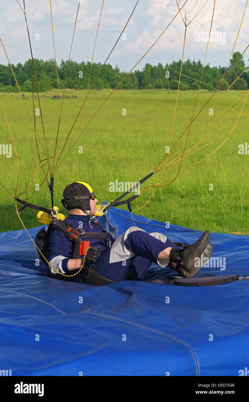 One day with parachutist in airfield. The skydiver landing on a blue ...