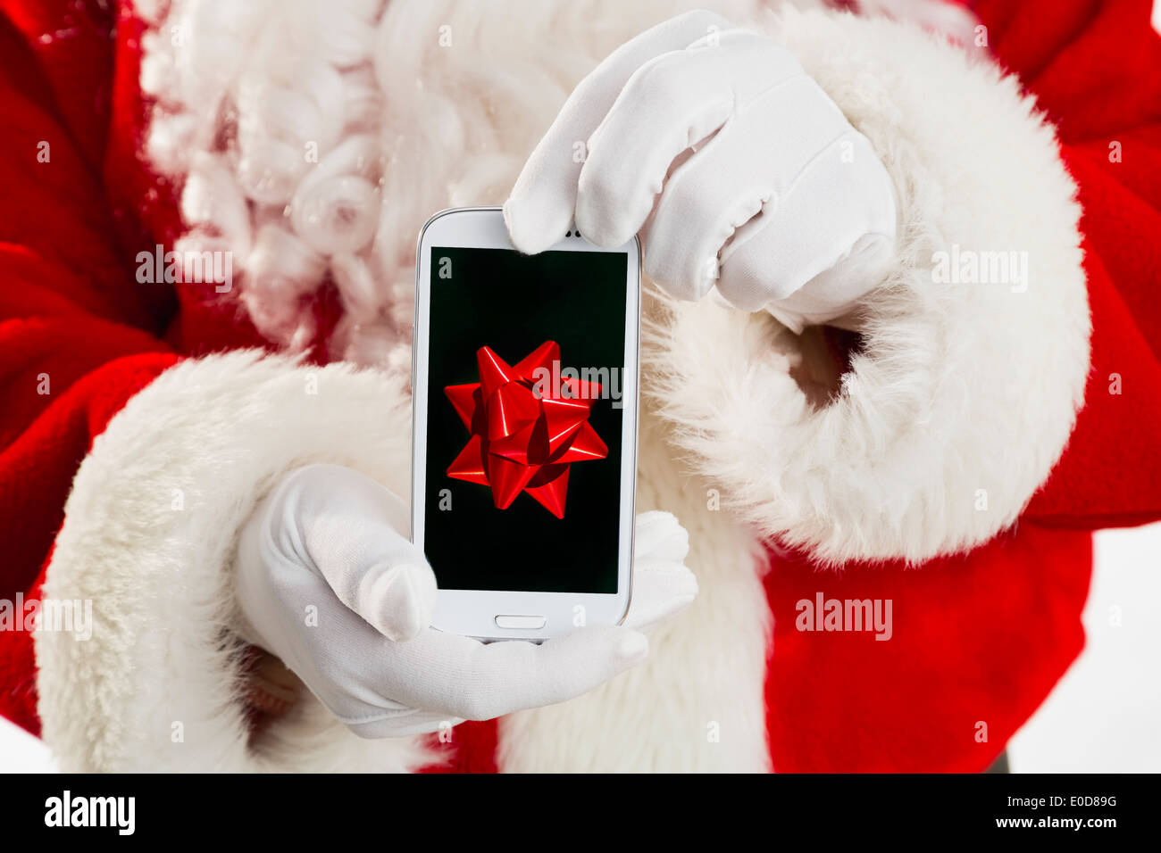 Mid section of Santa holding cell phone Stock Photo - Alamy