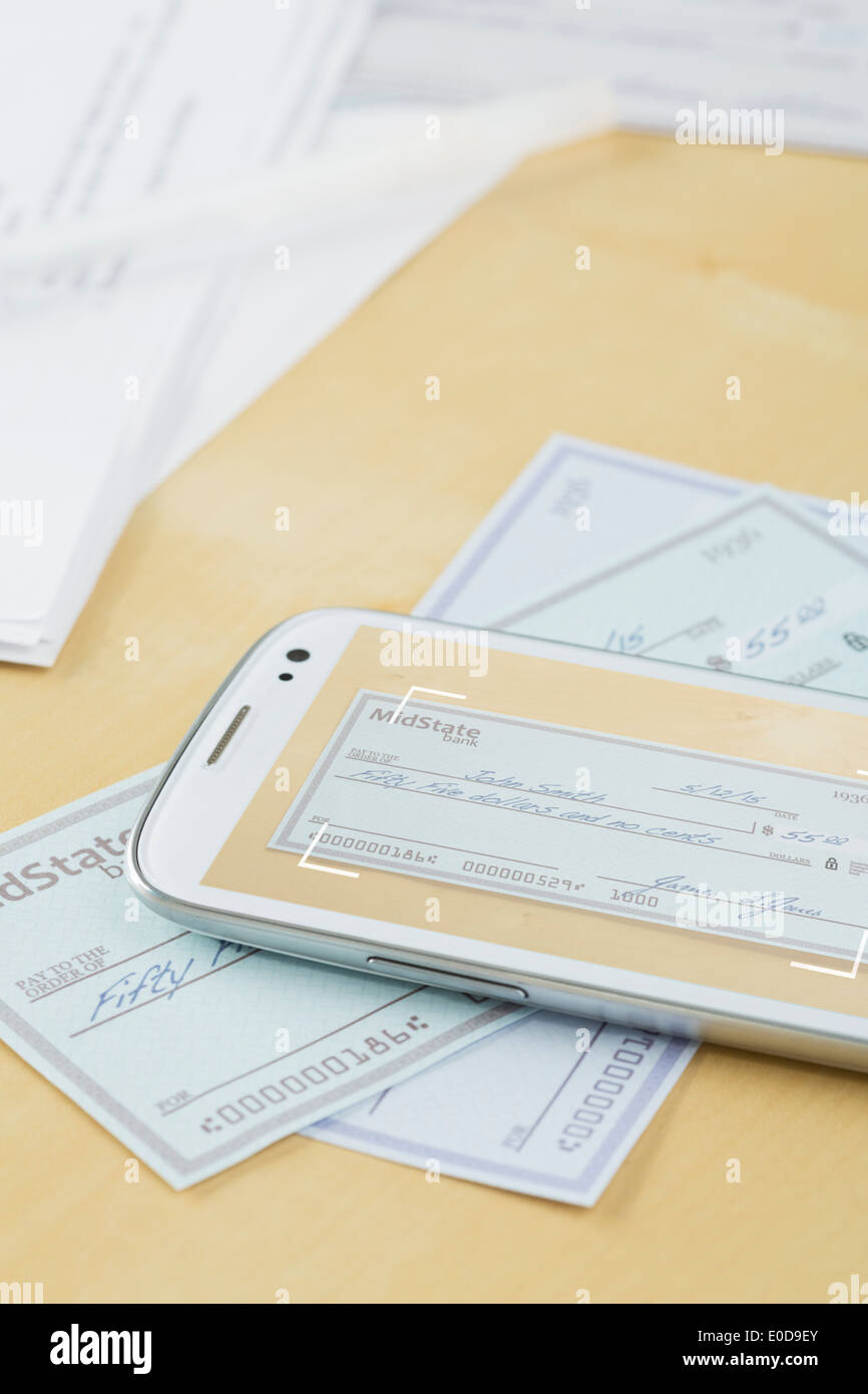Cheque and cell phone lying on table Stock Photo - Alamy