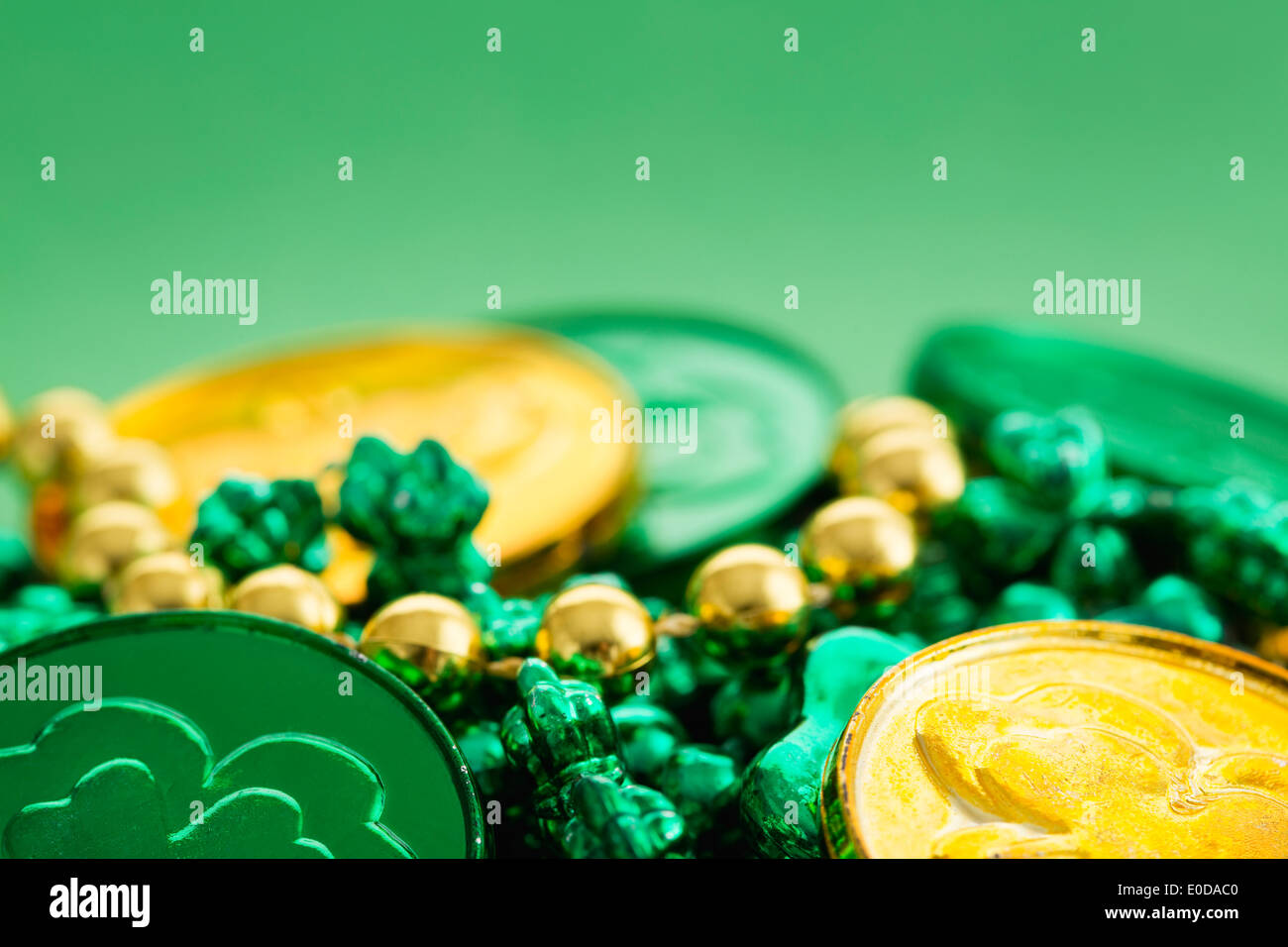 Gold and green coins and shamrock on green Stock Photo - Alamy