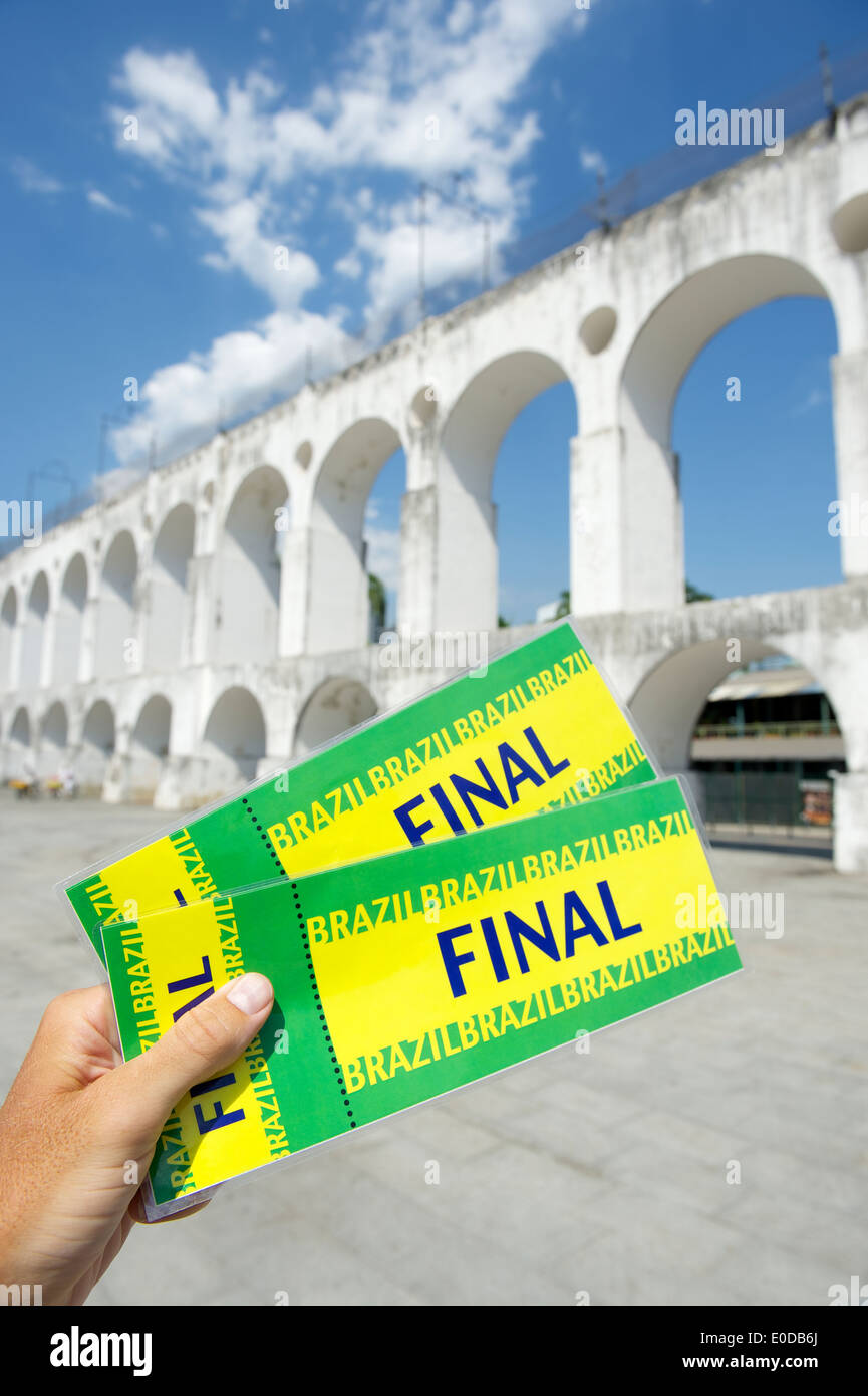 Hand holding two Brazil final tickets in front of Arcos da Lapa Arches ...