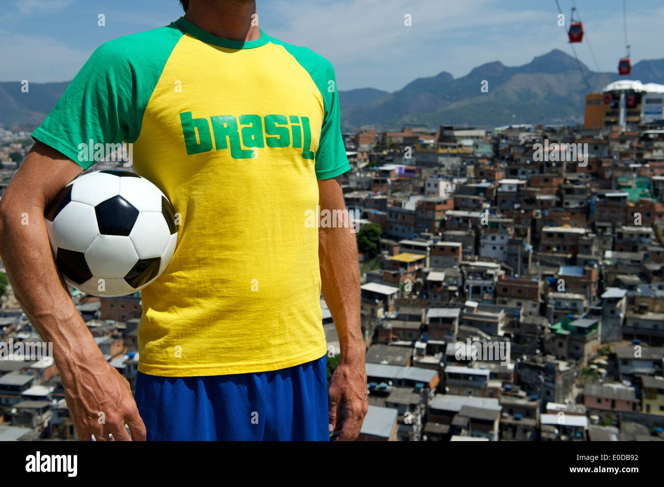 Brazilian football player standing in Brazil colors holding soccer ball ...