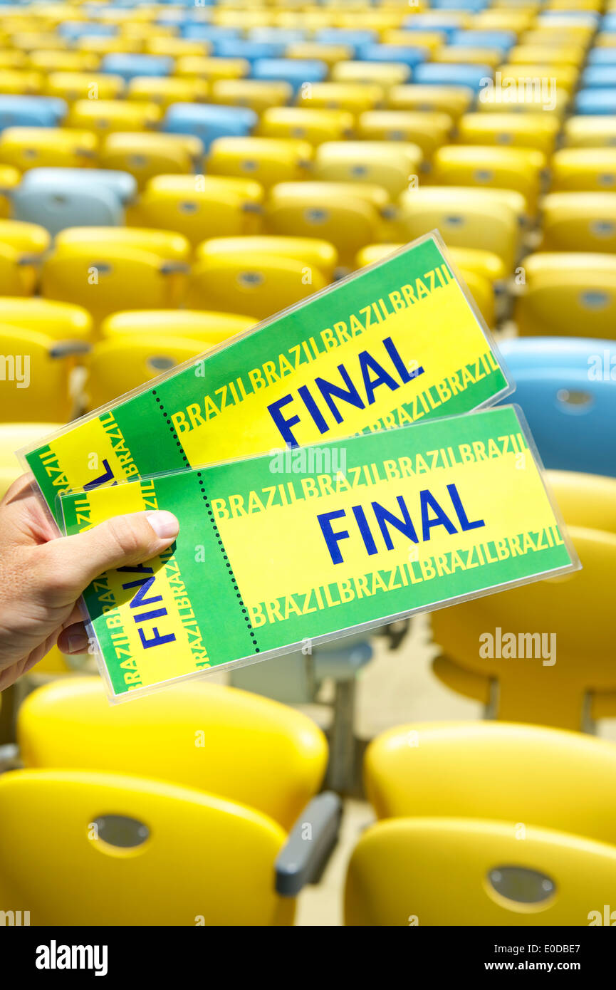 Soccer fan holding two Brazil final tickets in front of empty stadium ...