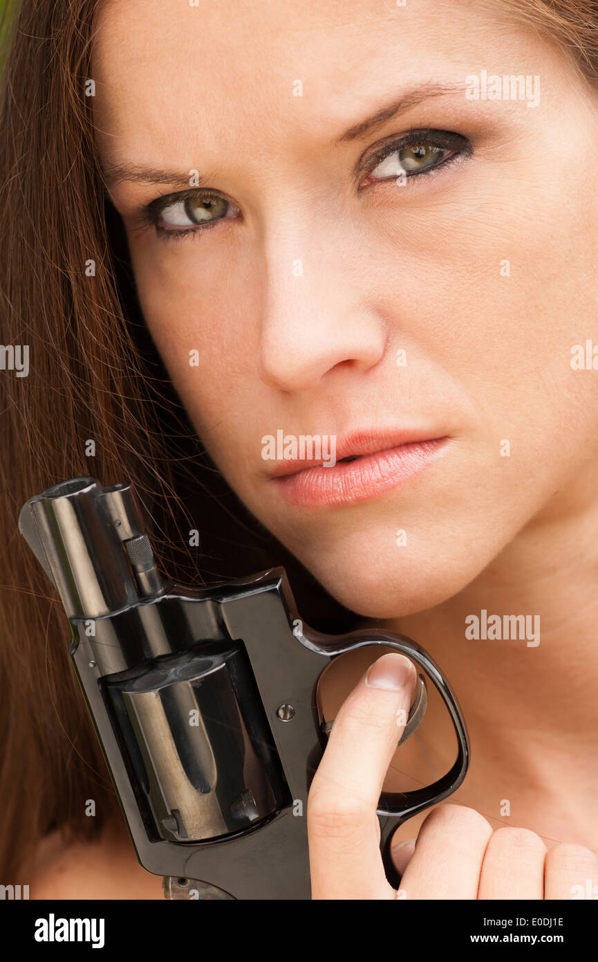 Woman holds revolver up to her face during a range session Stock Photo ...