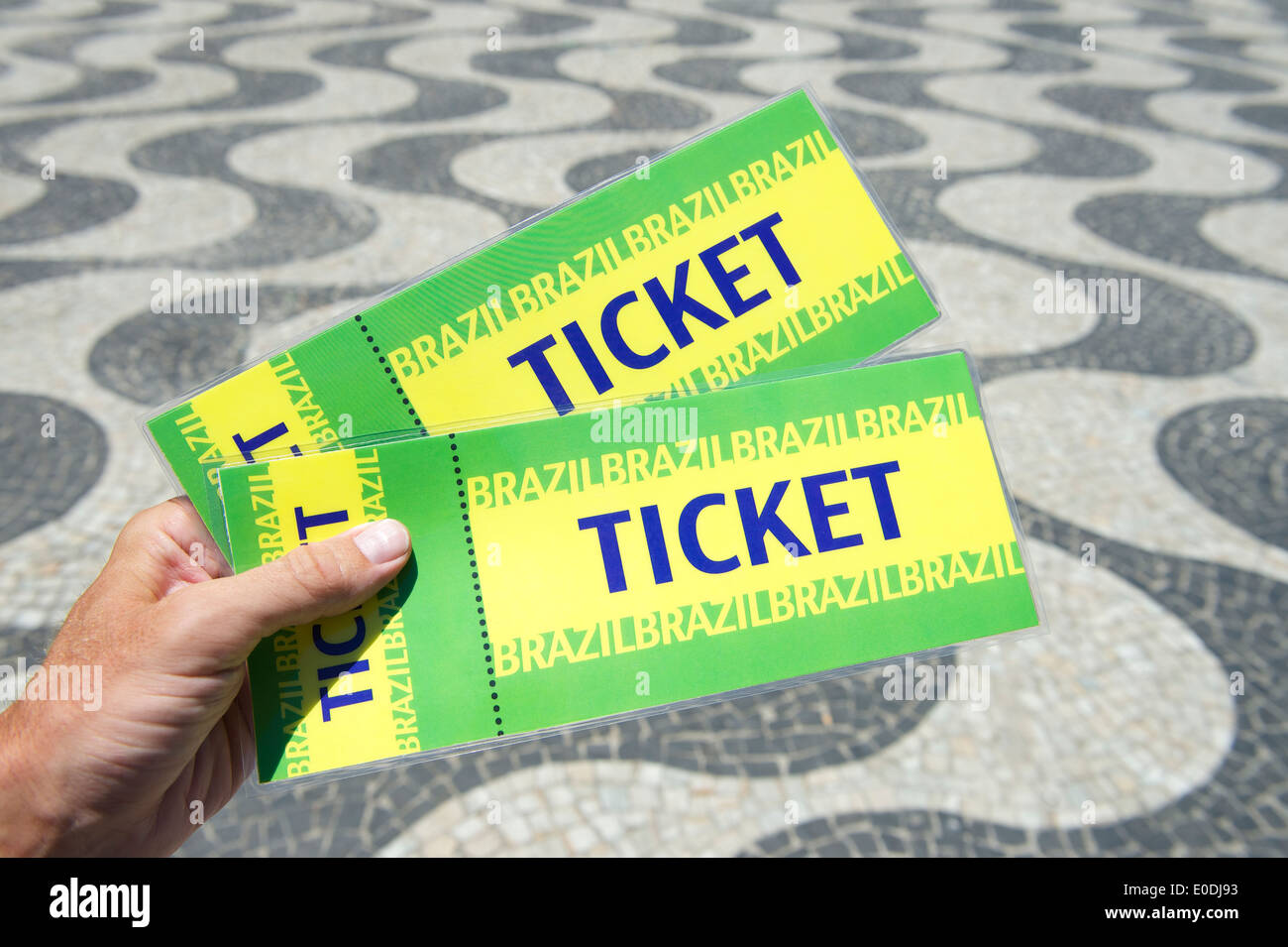 Hand holding two Brazil tickets at the Copacabana Rio de Janeiro ...