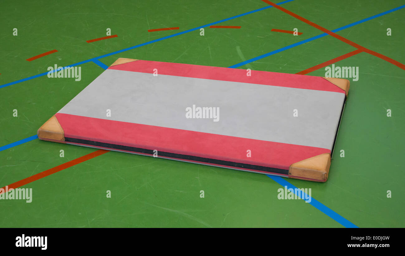Very old red mat on a blue court, school gym Stock Photo - Alamy