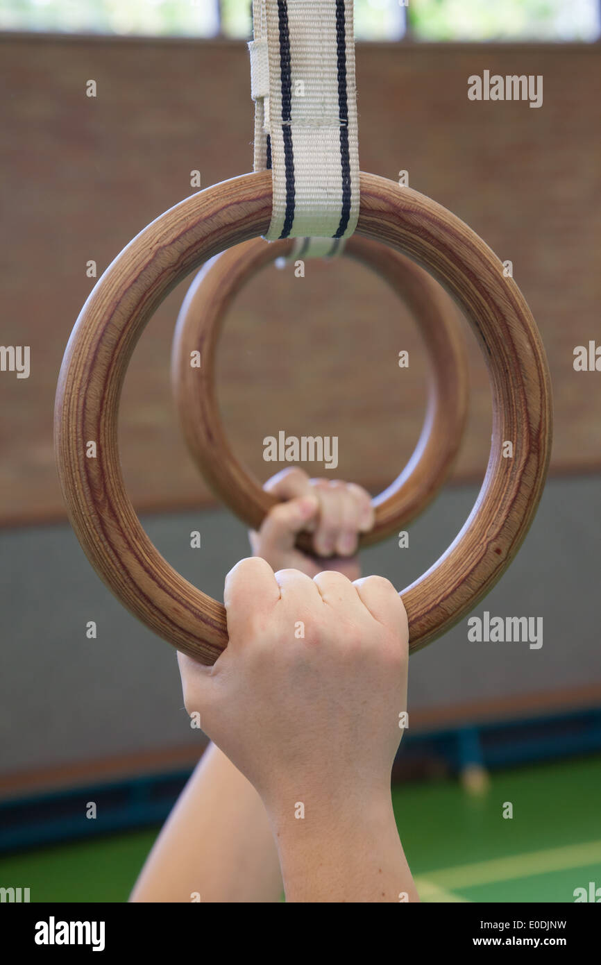 Human hanging in gymnastic rings, old school gym Stock Photo - Alamy