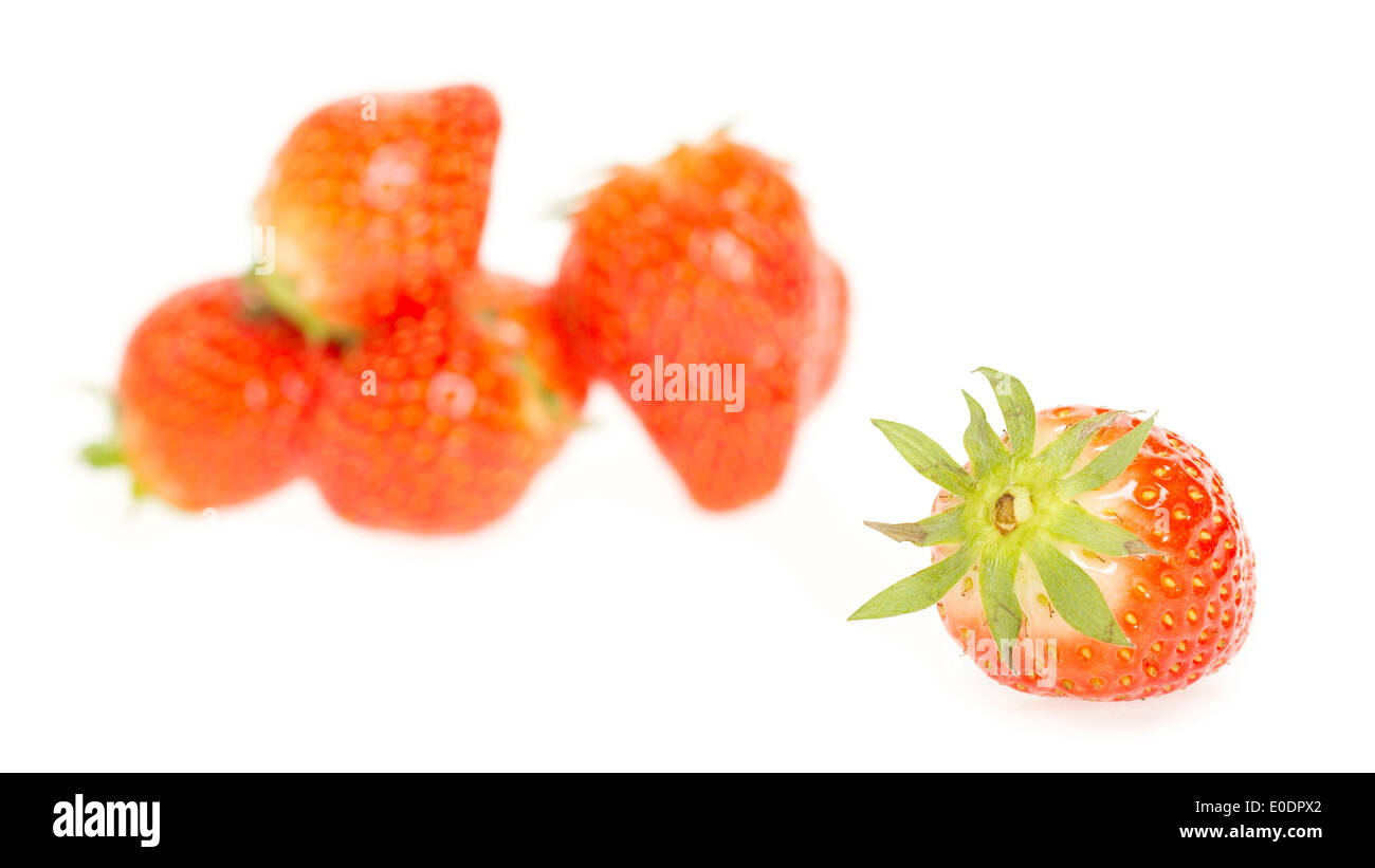 A fresh strawberry isolated in front of a stack of strawberries Stock ...