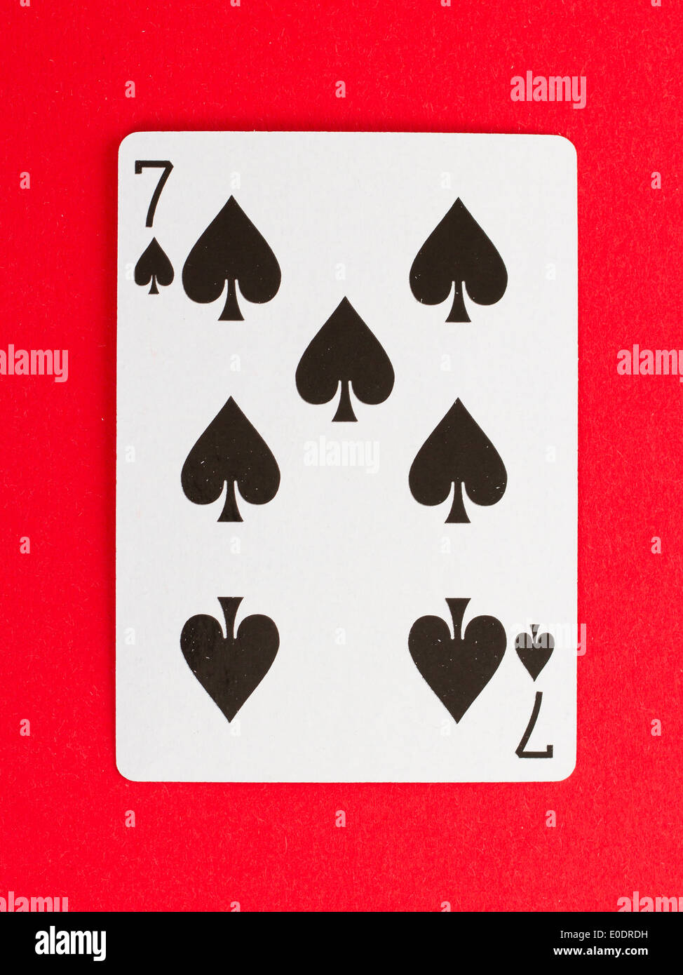 Old playing card (seven) isolated on a red background Stock Photo - Alamy
