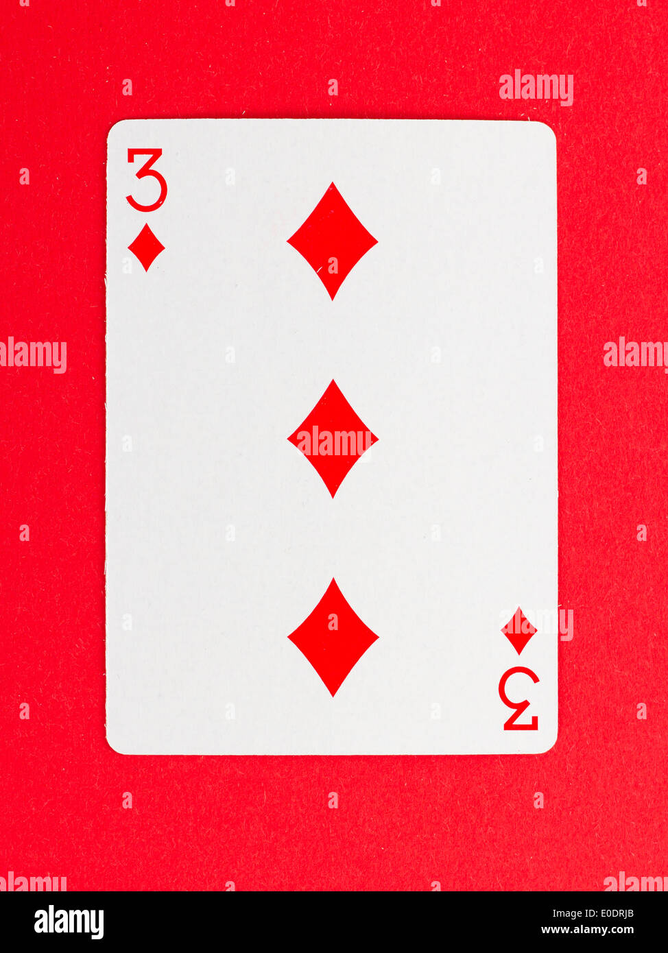 Playing card (three) isolated on a red background Stock Photo - Alamy