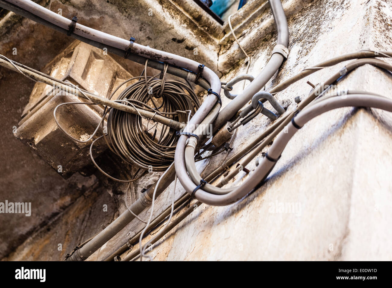 a messy elecrtical connection on the exterior facade of a building ...
