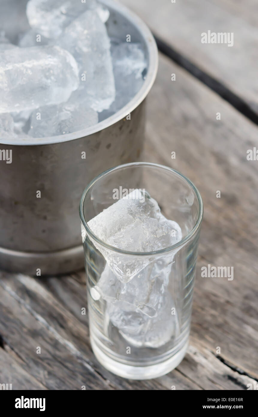 Glass with ice cubes and Ice bucket filled with ice cubes Stock Photo ...