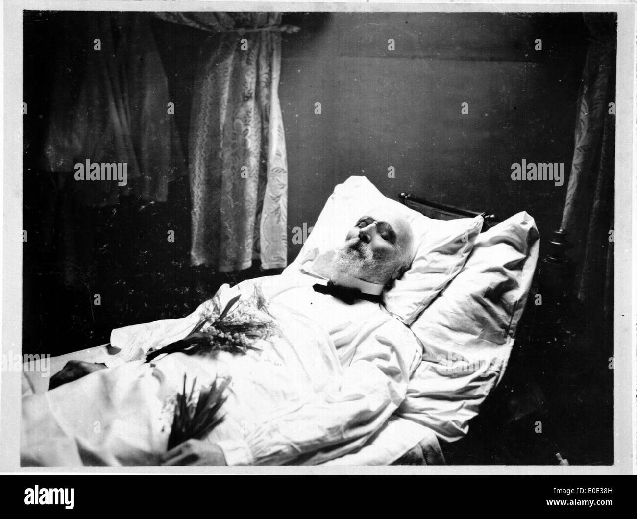A vintage black-and-white photograph featuring a deceased individual ...