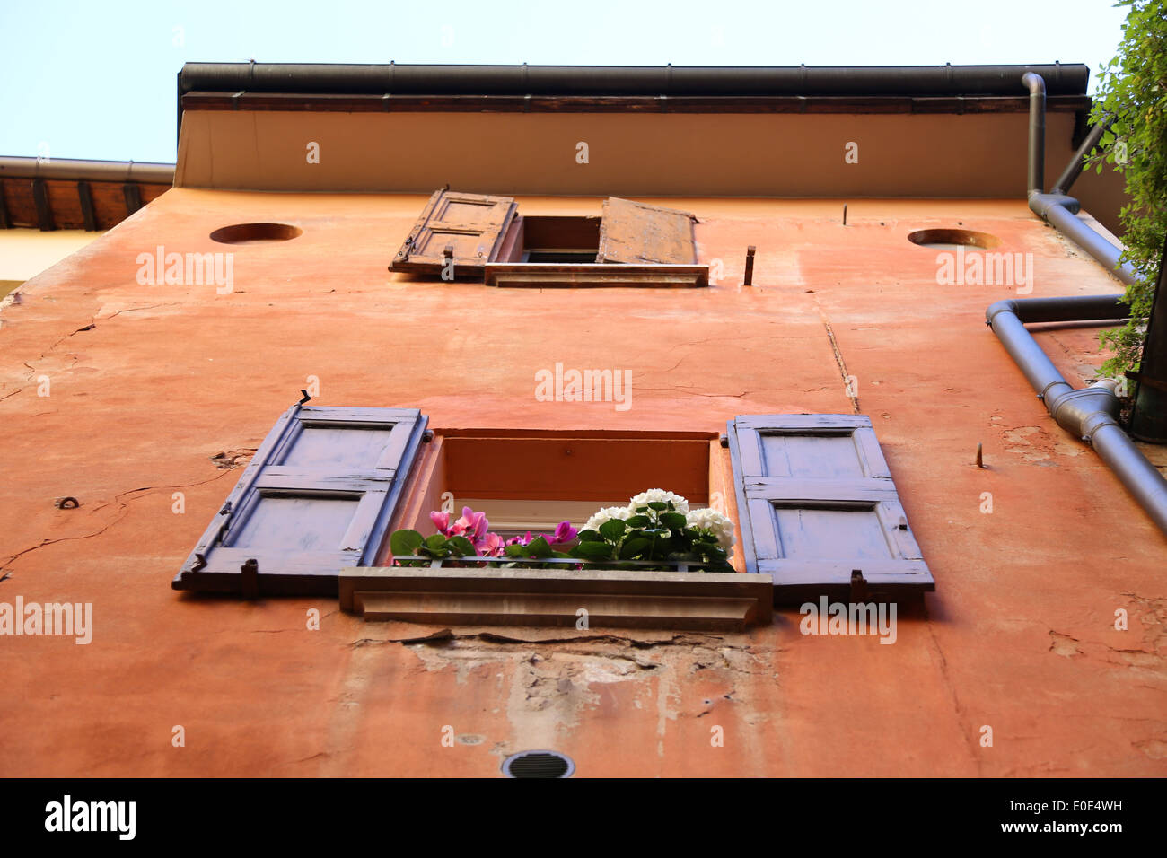 Window with open shutters and flowers - view from below Stock Photo - Alamy