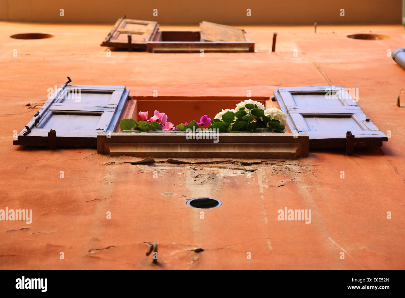 Window with open shutters and flowers - view from below Stock Photo - Alamy