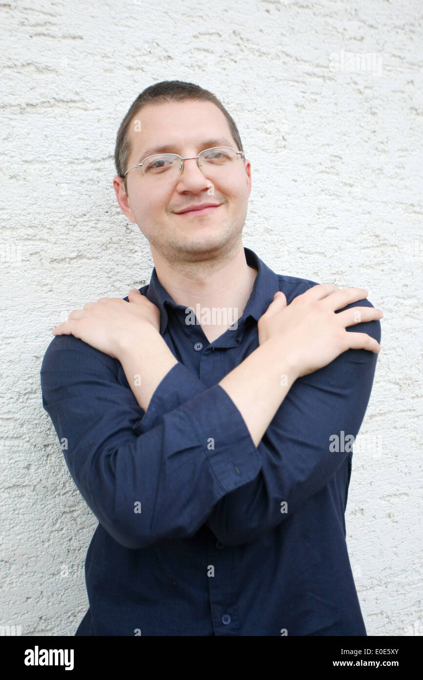 A portrait of a nicely dressed man posing with arms crossed on his ...