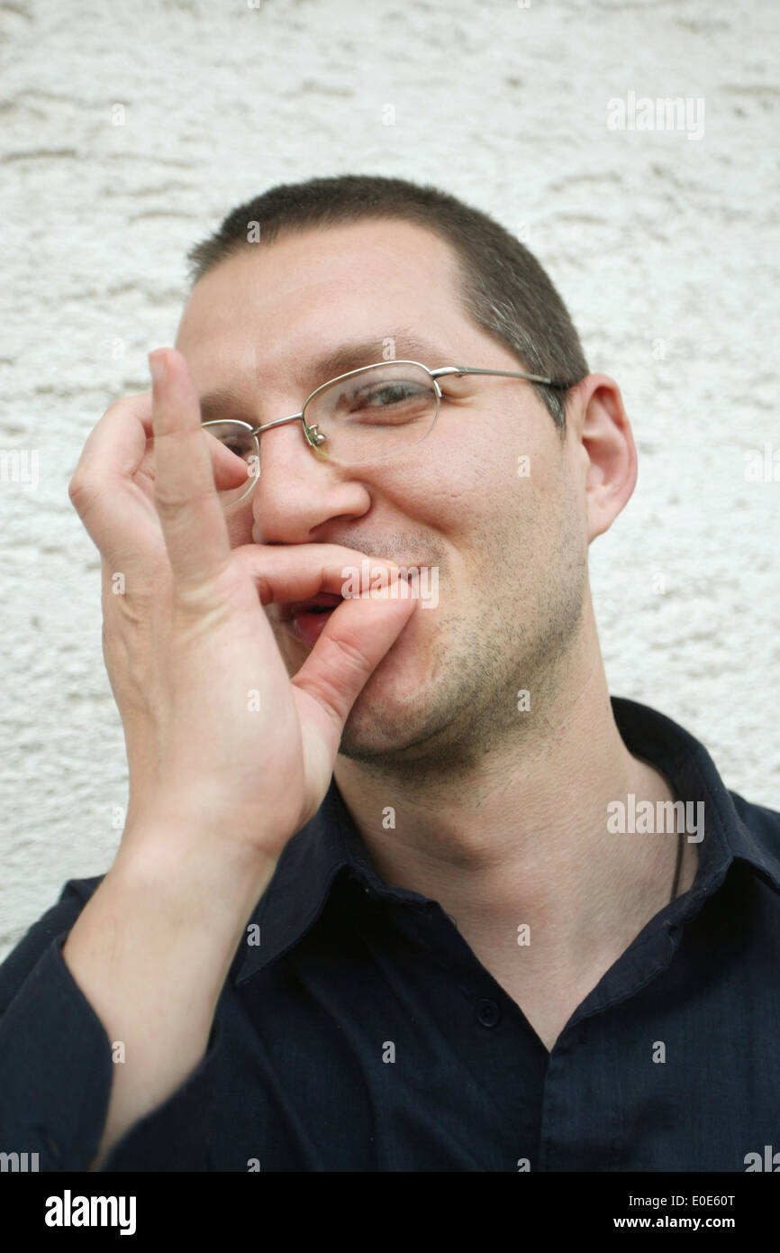 A portrait of a nicely dressed man that simulates cigarette smoking ...