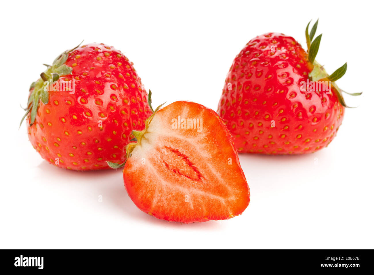 Organic ripe strawberries cut and whole over white background Stock ...