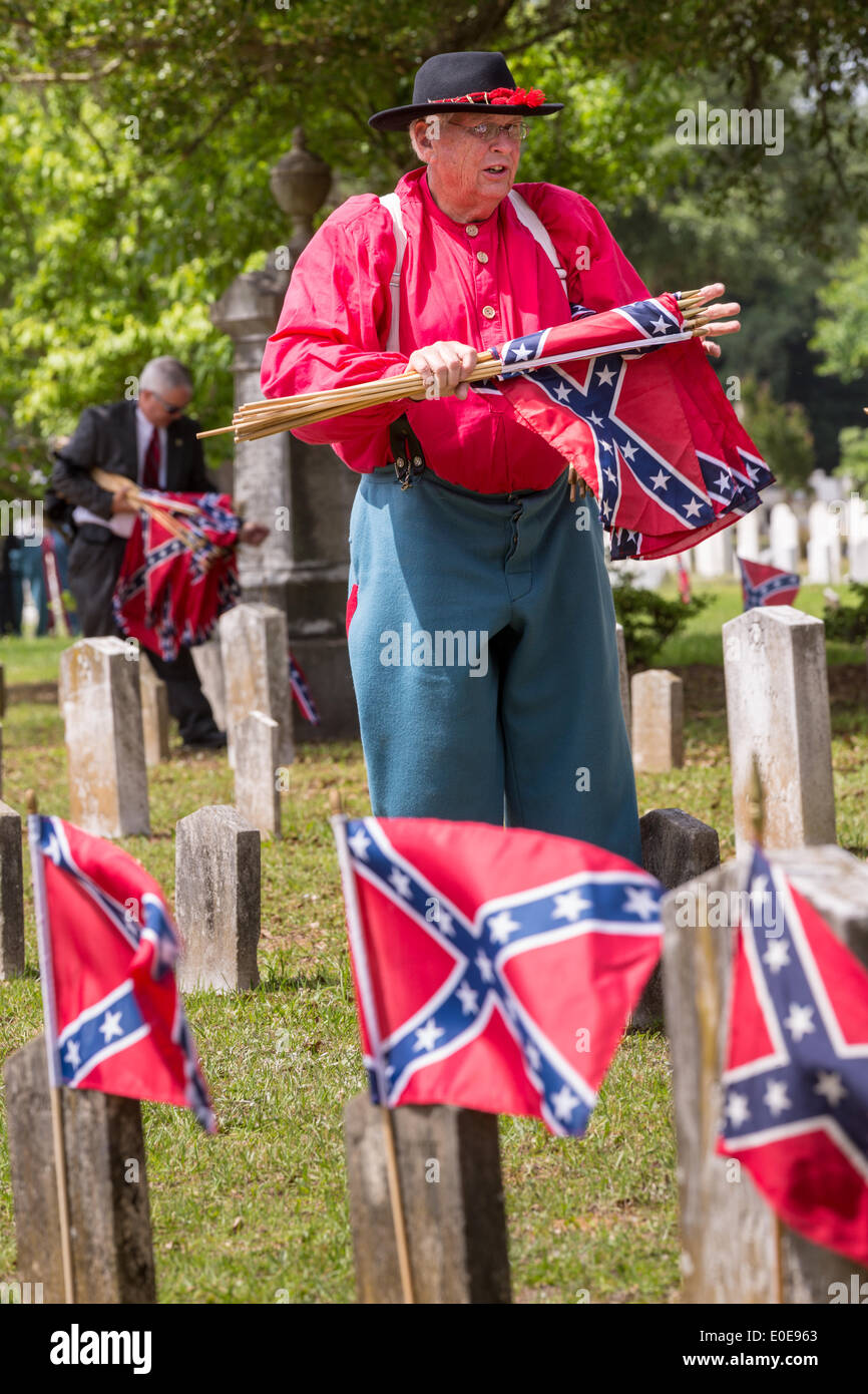 A Civil War re-enactor collects flags from grave sites following a ...