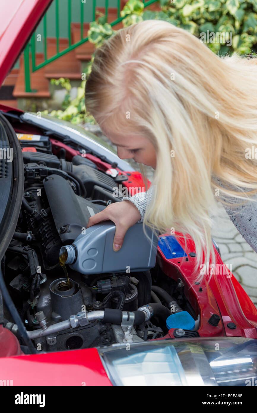 A young woman refills oil in her car Stock Photo - Alamy
