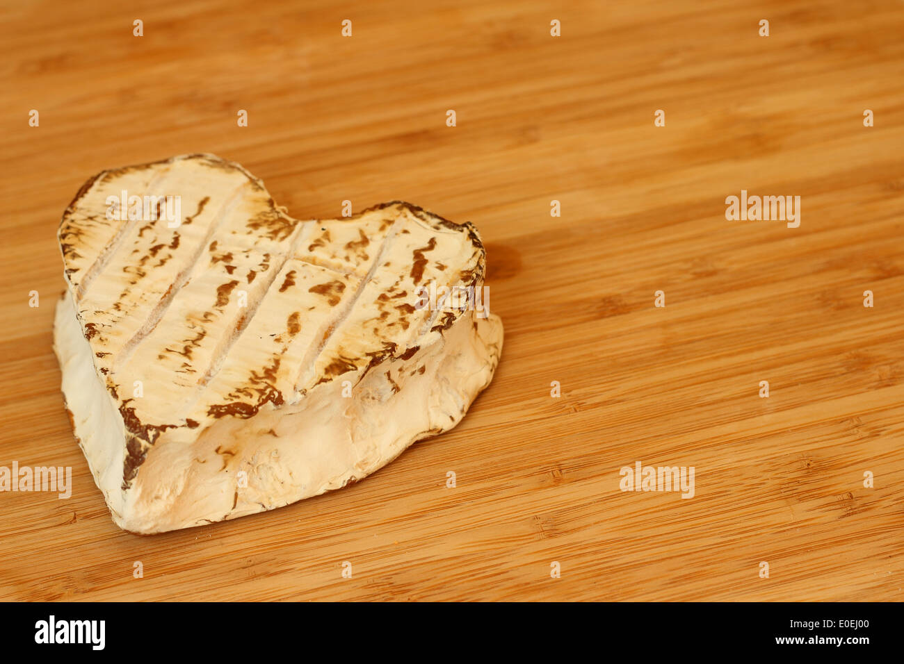 Neufchatel cheese shaped like heart on wooden cutting board Stock Photo ...