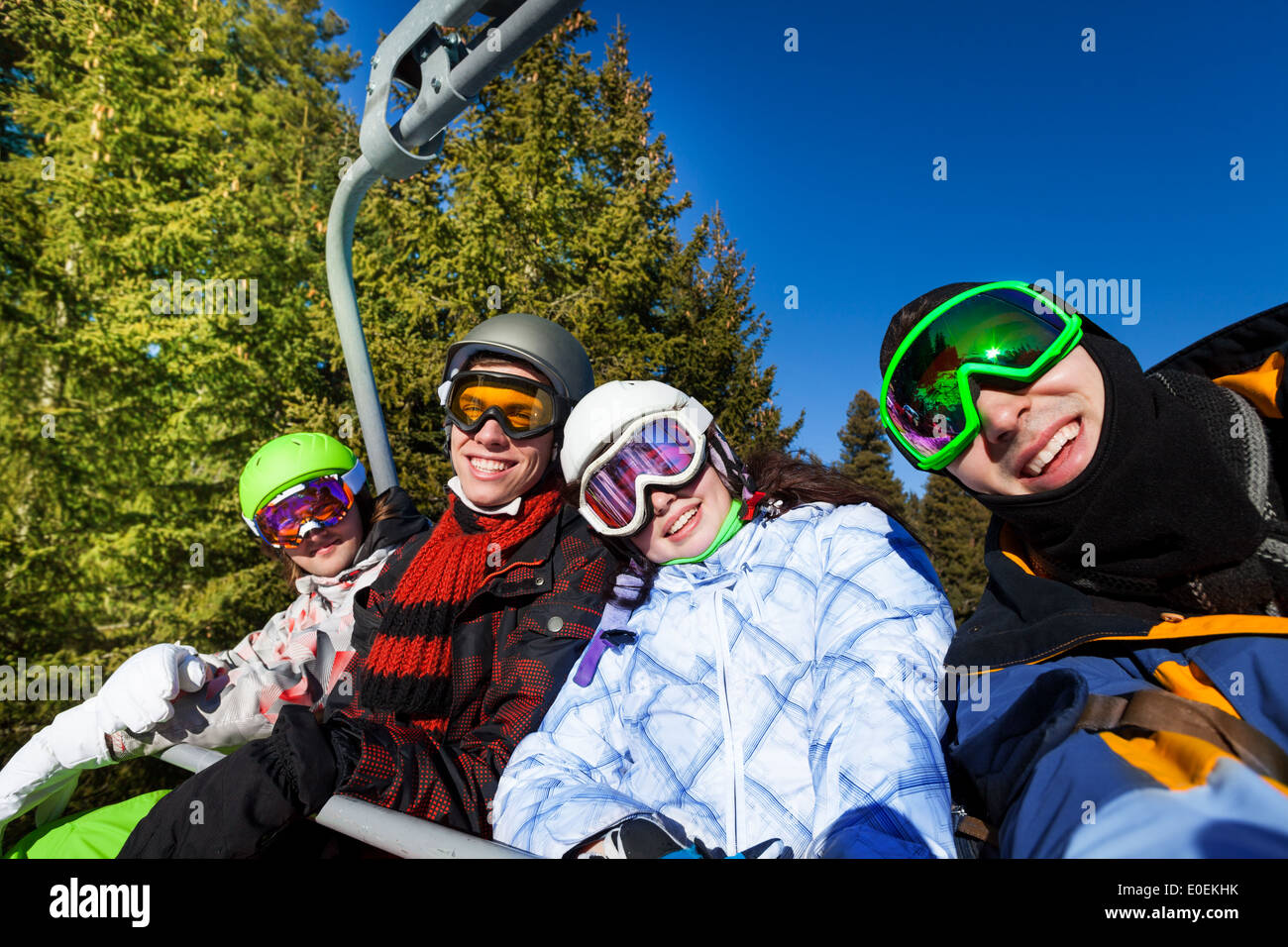 Smiling friends in ski masks sit on elevator Stock Photo - Alamy